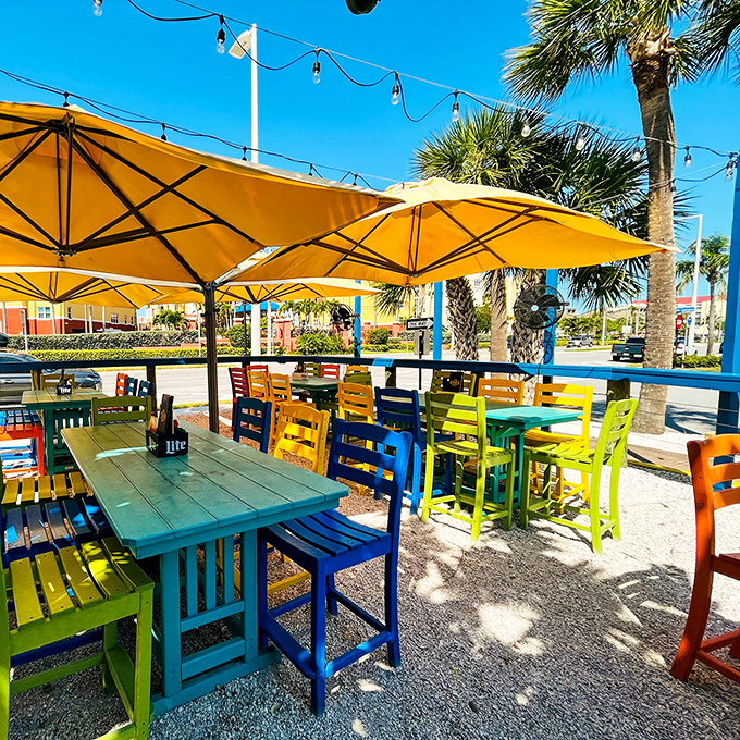 Outdoor tables in every shade of the tropical rainbow. This sun-dappled dining spot under yellow umbrellas is where memories are made between bites.