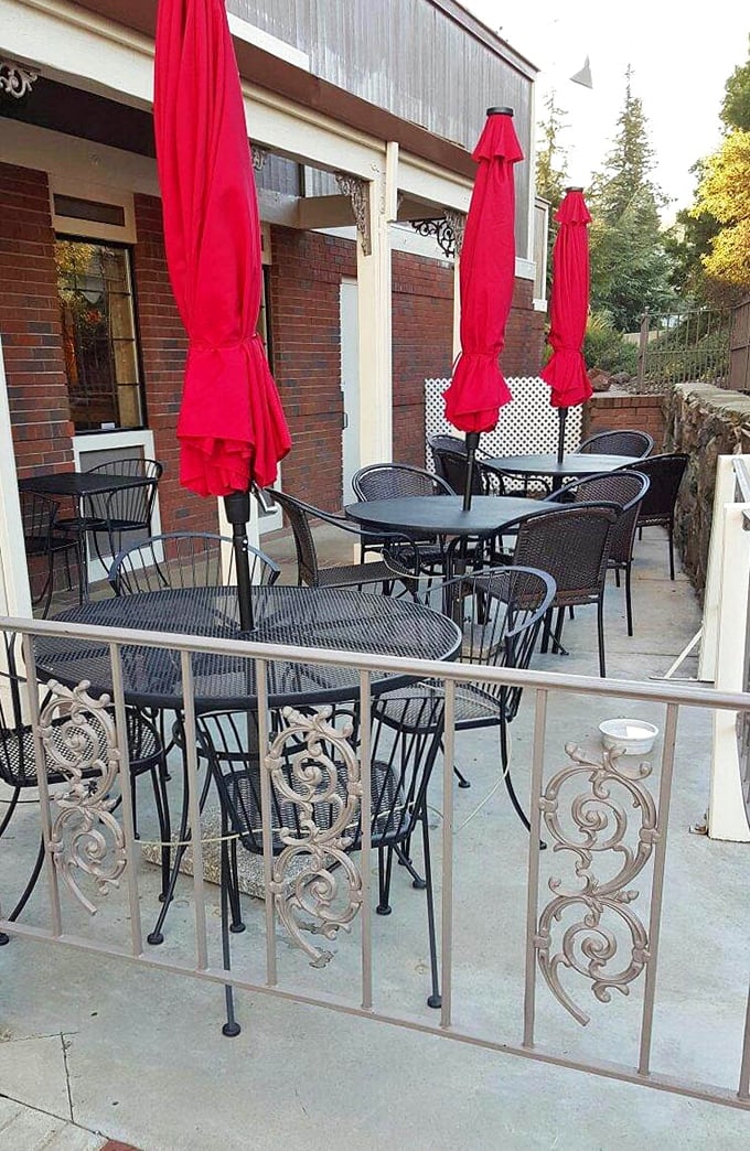 Al fresco dining, Gold Country style. Red umbrellas and wrought iron railings create a charming outdoor space for enjoying Placerville's perfect weather.