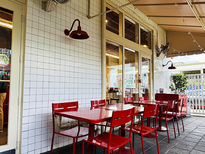 Red tables against white tiles create the perfect canvas for the real art: the conversation and connections that happen over great food.