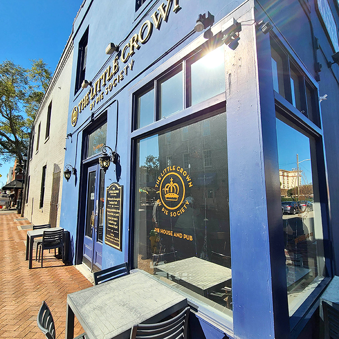 The Little Crown's striking blue exterior and gold lettering stand out in Savannah's historic district like a sapphire in a treasure chest.