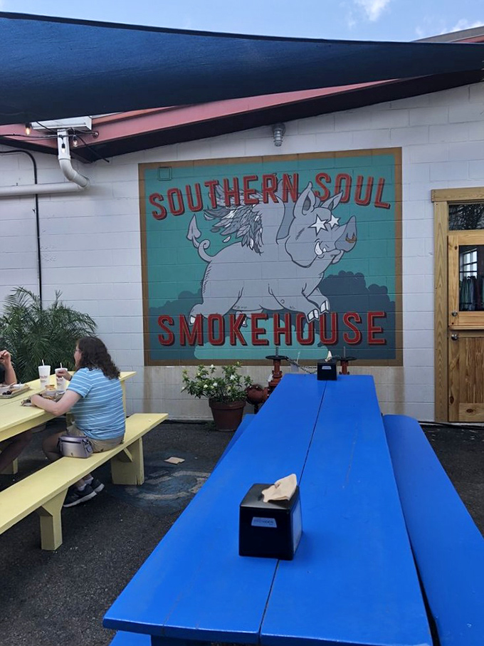 Outdoor seating beneath the watchful eye of the flying pig mural. In barbecue, pigs actually do fly—straight into the smoker and onto your plate.