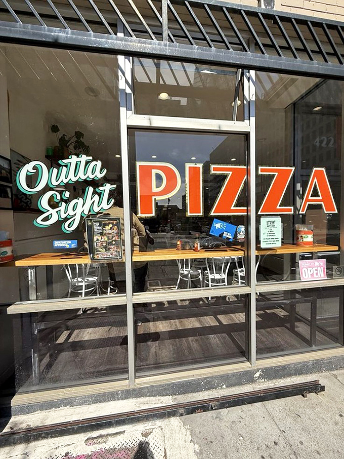 That mint script logo against bold red "PIZZA" letters&mdash;like a signature on a masterpiece. The storefront that launched a thousand cravings. 