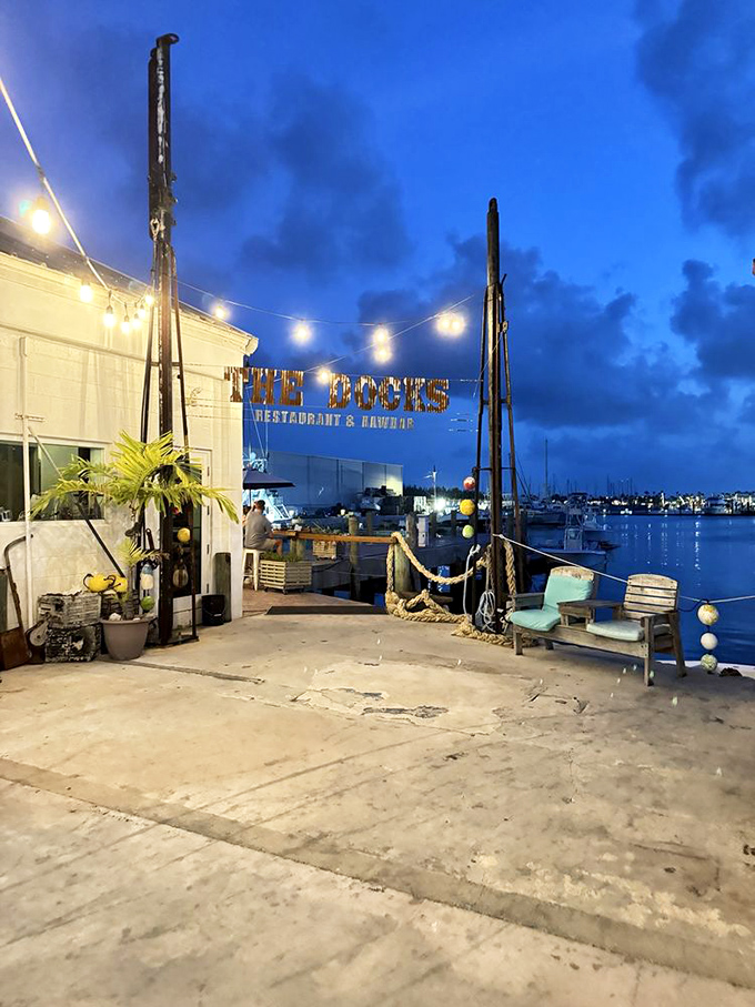 As twilight embraces the harbor, The Docks transforms into a beacon of culinary promise against the deepening blue Florida sky.