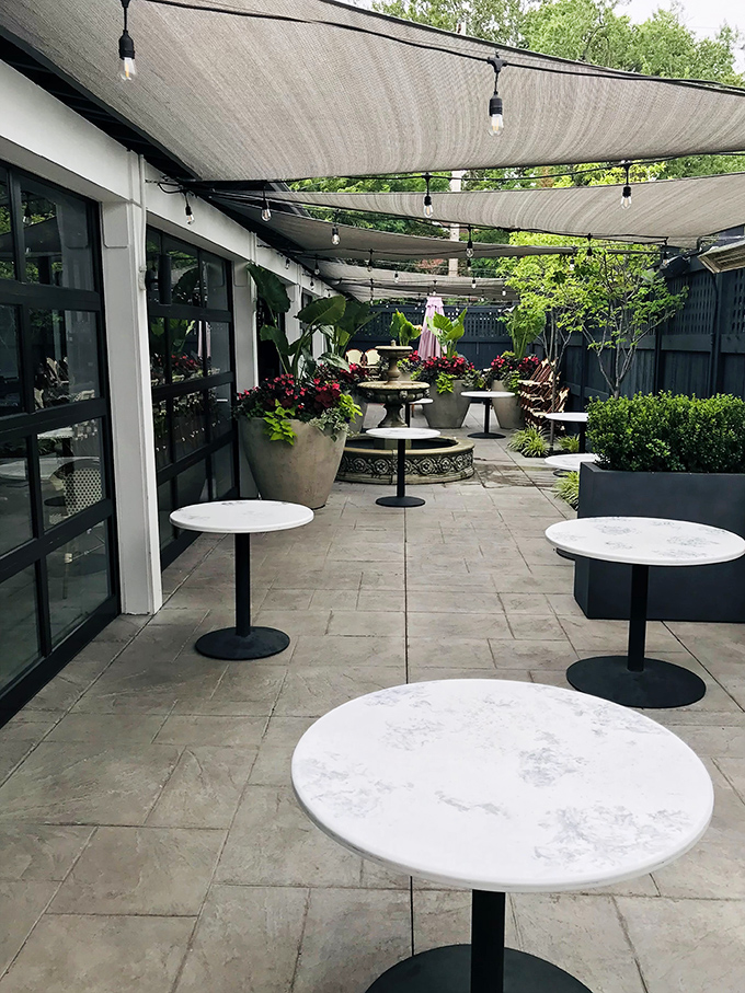 The outdoor patio's clean lines and marble tabletops create a sophisticated urban garden where summer evenings stretch longer than your post-dinner contentment.