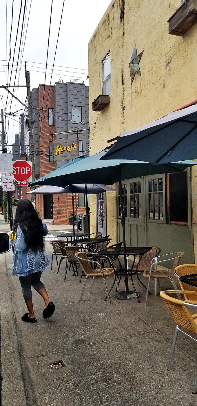 The sidewalk approach feels like discovering a secret &ndash; yellow walls, blue umbrellas, and wicker chairs patiently waiting for your breakfast stories.