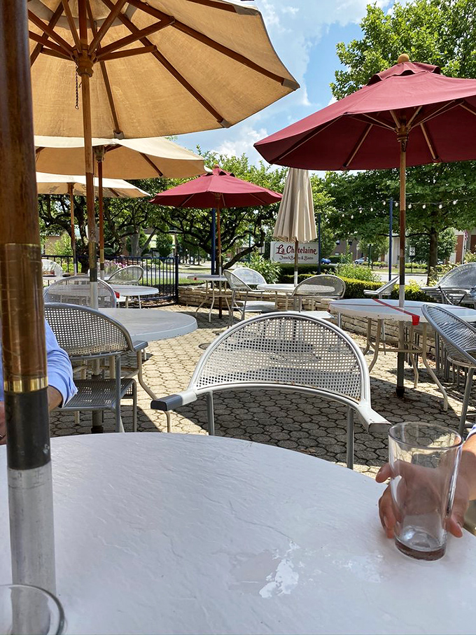 Red umbrellas standing guard over tables where memories are made&mdash;one croissant, conversation, and coffee at a time.