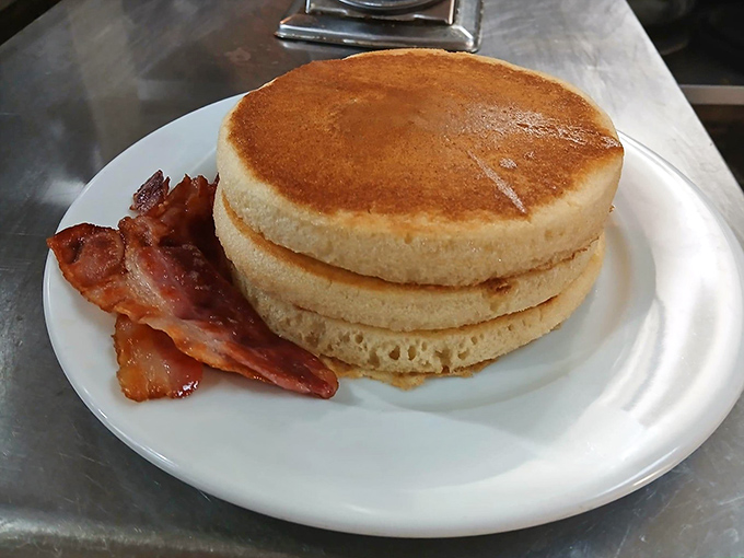 Pancakes stacked higher than your weekend expectations, with bacon that's achieved that perfect crispy-but-not-too-crispy sweet spot.