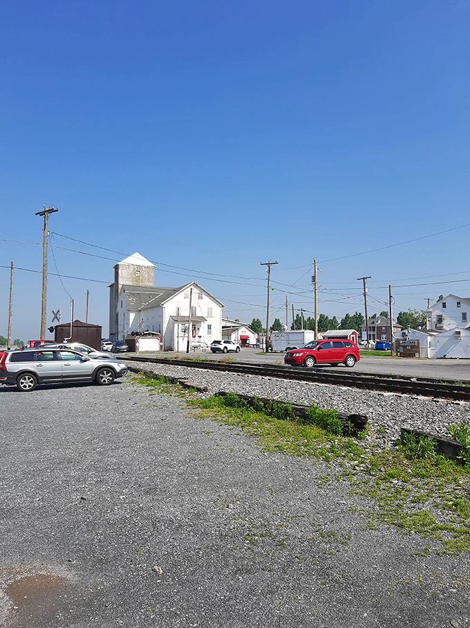 Railroad tracks frame this quintessential small-town scene where flea market magic happens every single Tuesday.