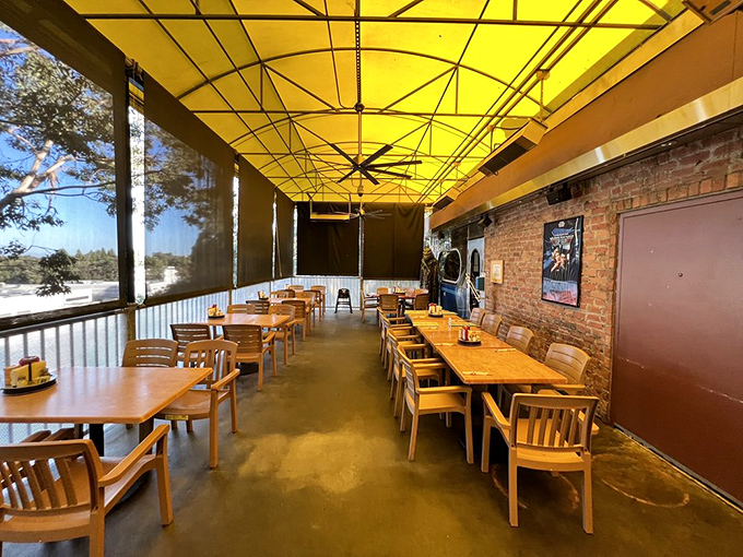 The outdoor patio scene&mdash;yellow canopy overhead, wooden tables below, and brick walls creating the perfect setting for your next breakfast sequel.