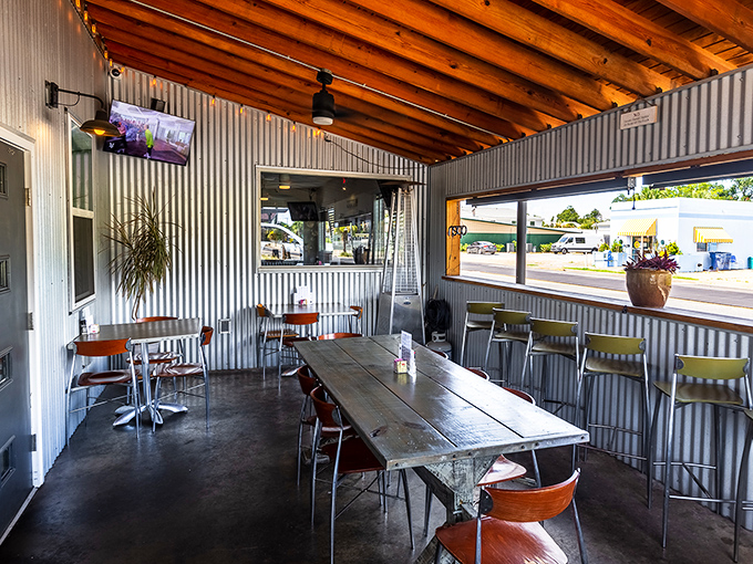 Corrugated metal walls, wooden ceiling beams, and simple furnishings create an unpretentious outdoor space where the Gulf breeze delivers appetizers of fresh air before your meal arrives.
