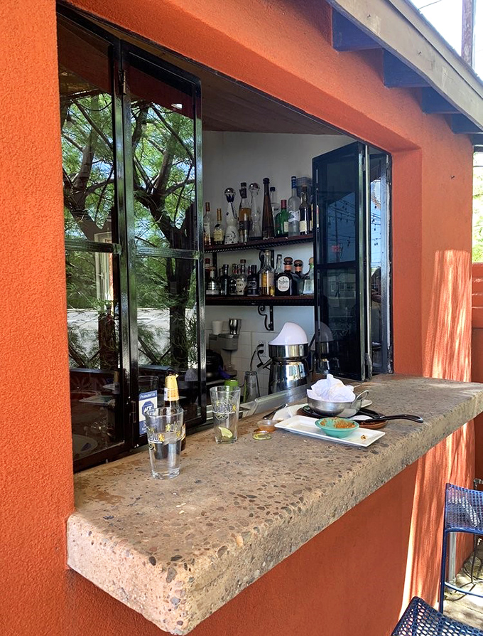 The outdoor bar window frames the Arizona greenery perfectly, creating a natural backdrop for that "one more margarita" you definitely deserve.