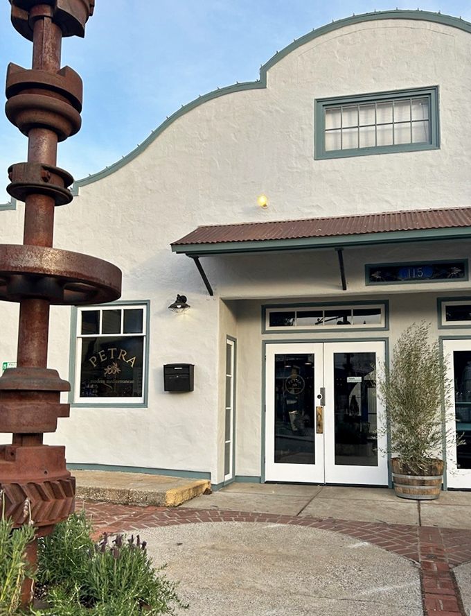 Petra Mediterranean's distinctive architecture stands out with its curved roofline. That industrial sculpture outside hints at the artistic approach to cuisine within.