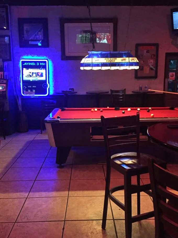 The pool table waits in blue-lit anticipation for post-dinner competition. Many friendships have been tested and strengthened over these felt-covered rails.