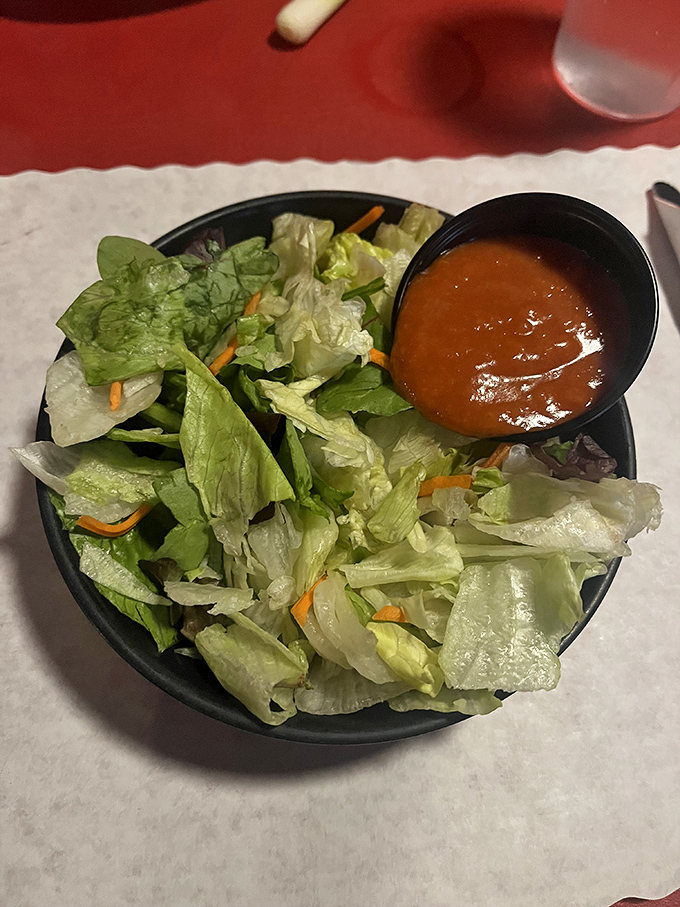 Even the side salad gets respect here &ndash; a crisp, fresh counterpoint to the richness that follows, proving that balance exists in all great meals.