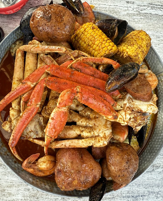 A seafood boil that's basically a treasure chest for hungry pirates&mdash;crab legs reaching skyward like they're still trying to escape their delicious fate.