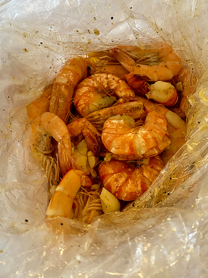 Peek inside the seafood bag and witness the magic—seasoned shrimp and potatoes swimming in buttery, spice-infused glory. This is what seafood dreams are made of.