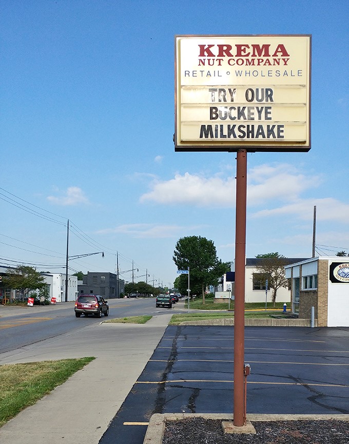 The roadside sign beckons like a nutty lighthouse guiding hungry travelers to shore. That Buckeye Milkshake call-out is pure Ohio poetry.