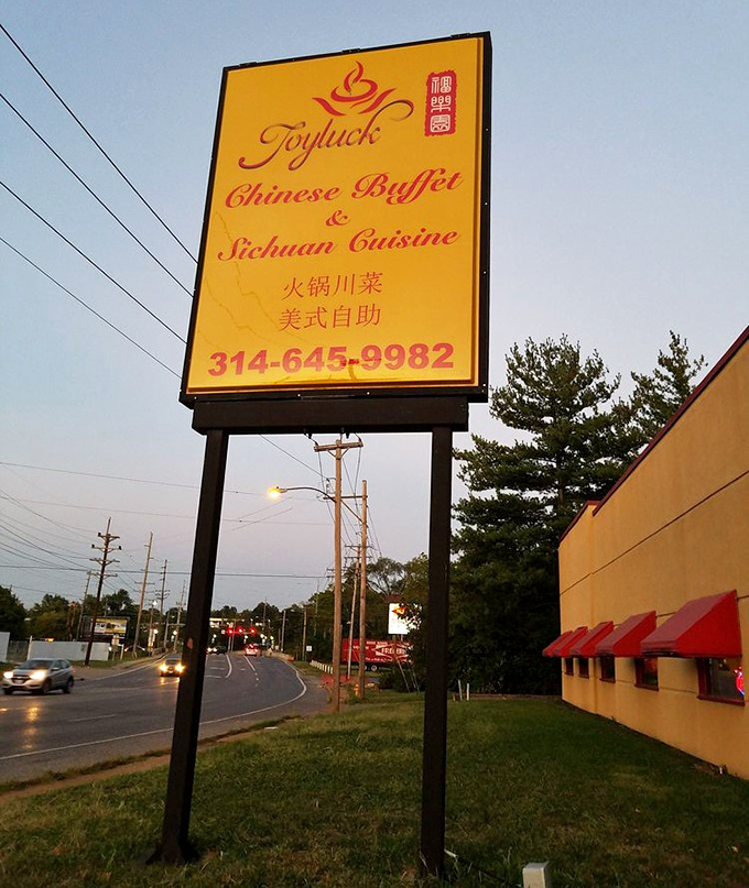 The roadside sign glows like a golden invitation as dusk settles, beckoning hungry travelers with the promise of Sichuan specialties and buffet bounty.