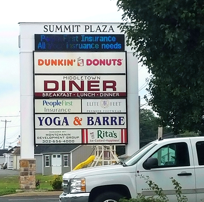 The Summit Plaza sign announcing the diner like it's sharing breaking news. When you're sandwiched between yoga and donuts, you're everyone's solution.