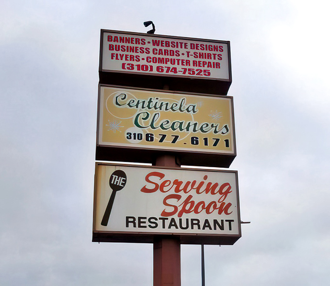 The roadside sign stands as a beacon of hope for hungry travelers. Follow it like sailors following a lighthouse to delicious shores.