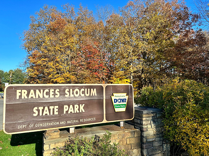 Fall foliage provides the perfect backdrop for the park entrance sign. Mother Nature's annual color show makes even official signage look Instagram-worthy.