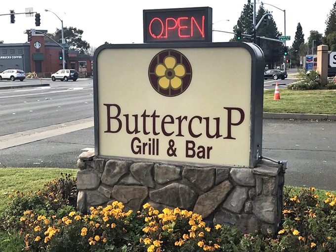 The roadside sign stands proud, surrounded by cheerful yellow flowers that echo the Buttercup logo&mdash;a beacon for hungry travelers.