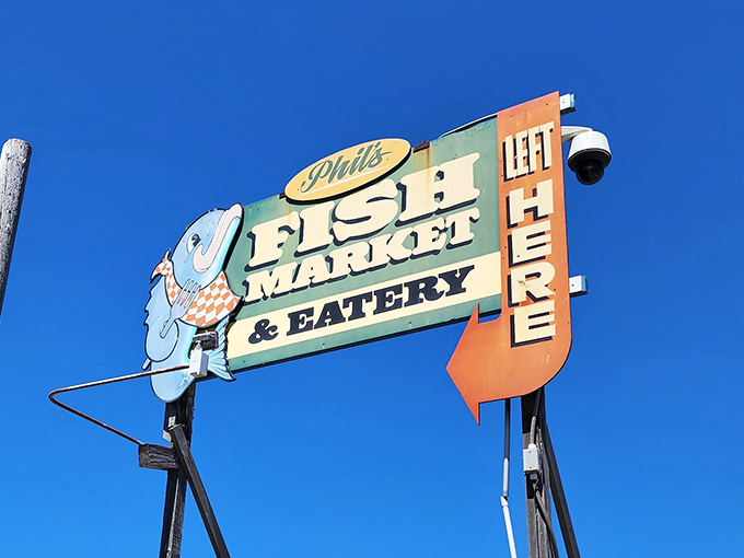 That retro sign pointing left isn't just directions&mdash;it's pointing the way to seafood enlightenment. The cartoon fish knows what you're in for.