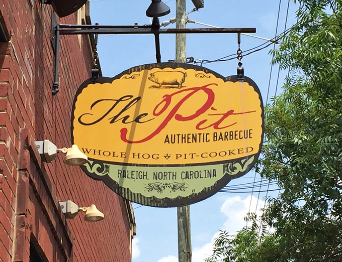 The golden sign swings like a beacon to barbecue pilgrims. "Whole Hog • Pit-Cooked" tells you everything you need to know about the treasures within.