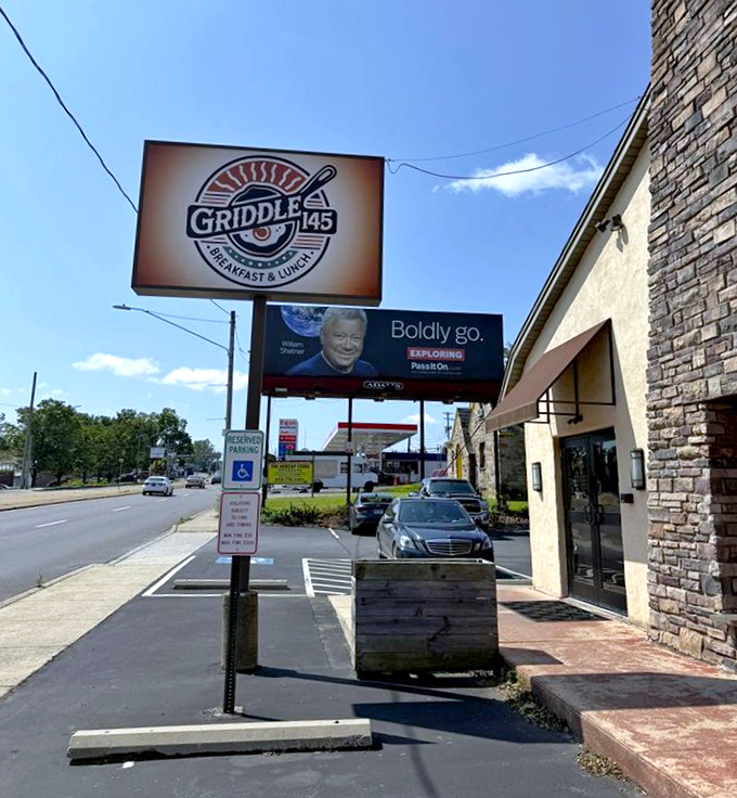 The roadside sign beckons to hungry travelers like a breakfast lighthouse guiding ships through morning hunger storms.