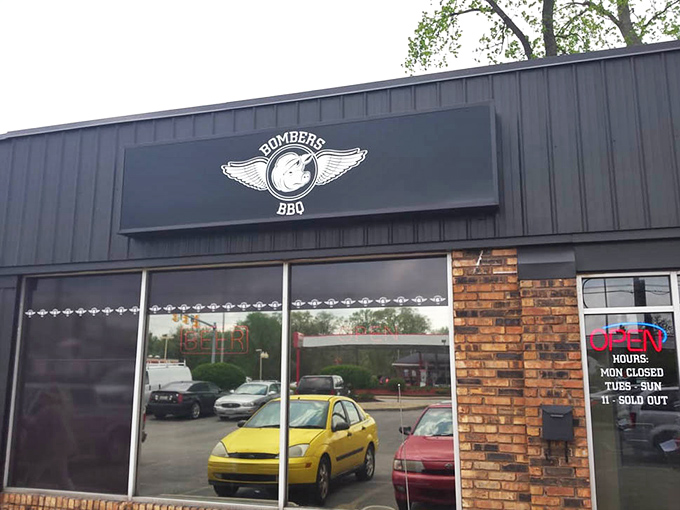 The winged logo of Bombers BBQ stands as a beacon of hope for meat lovers. Note the hours&mdash;they close when they sell out!