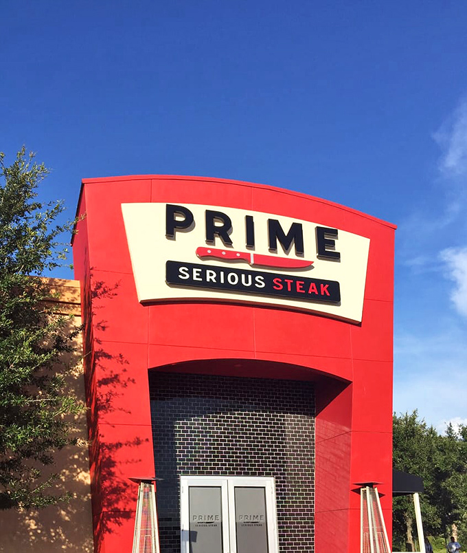 PRIME's daytime facade stands bold against Florida's blue sky. The red exterior promises passion inside &ndash; for meat, for dining, for excellence.