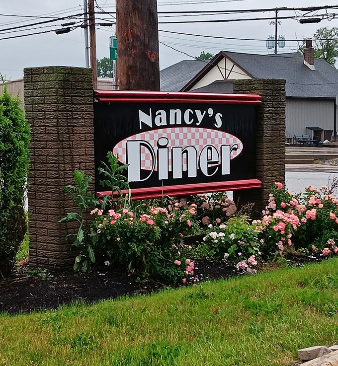 The sign that's guided hungry travelers for years, surrounded by flowers as if nature itself is saying "You've made an excellent choice."