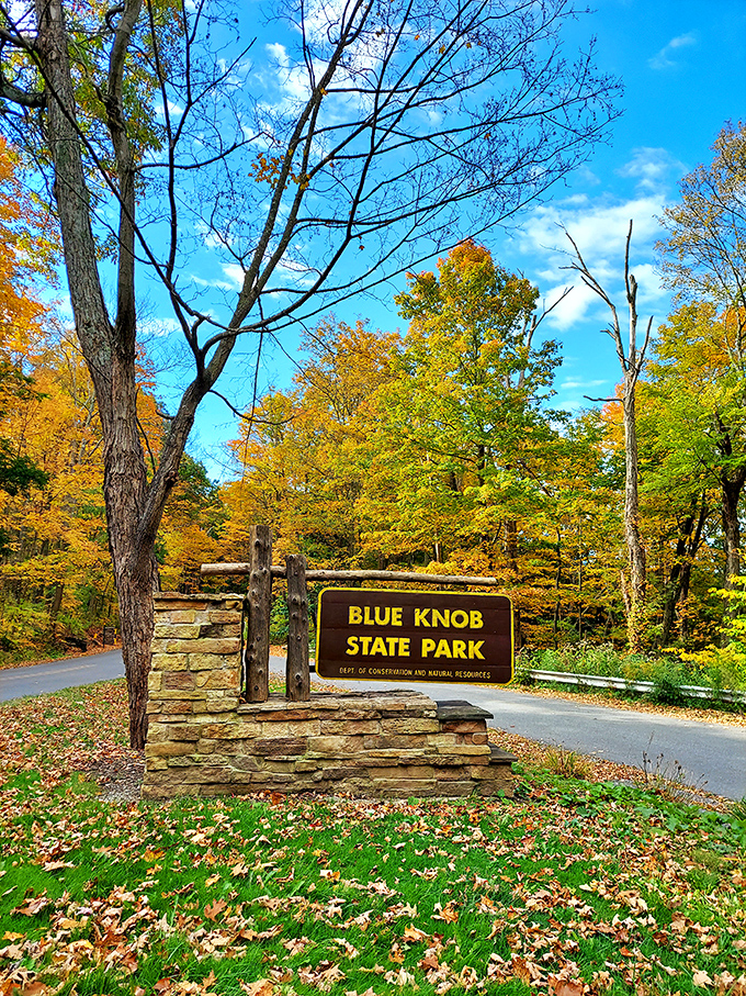 Fall's fiery display frames the entrance to Pennsylvania's hidden gem, where adventures begin with a drive through nature's color explosion.