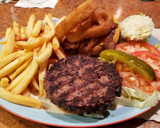 A burger that demands to be photographed before eaten, complete with the holy trinity of diner sides&mdash;fries, rings, and pickle spears.