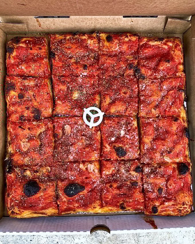 The square tomato pie &ndash; a canvas of red sauce artistry with crispy edges that make you wonder why circles ever became the pizza standard.