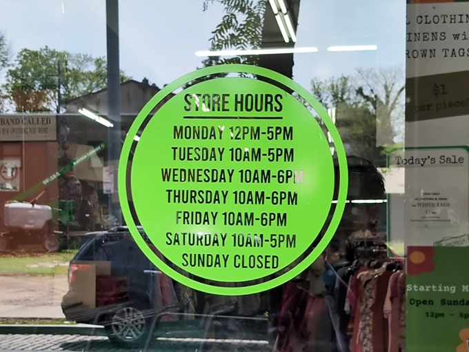 Store hours posted in neon green—the roadmap to planning your thrifting adventure with military precision.