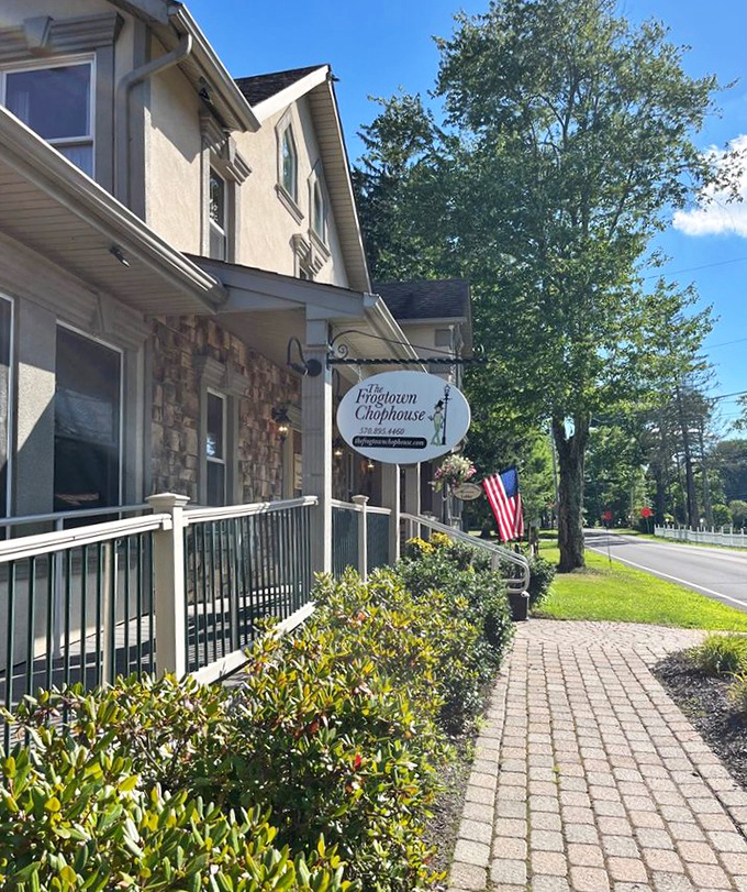 Sunlight bathes the charming entrance, where a brick pathway leads to a doorway that might as well be labeled "Delicious Things This Way."