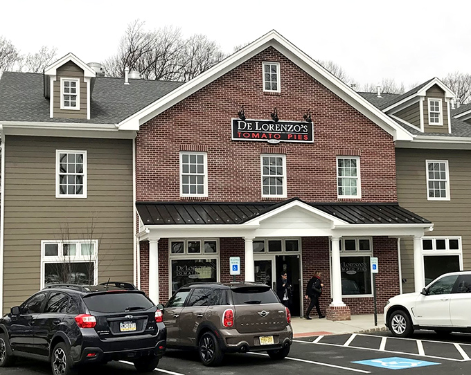 The classic storefront stands ready for another day of tomato pie magic. Those cars in the lot? Pilgrims at their destination.