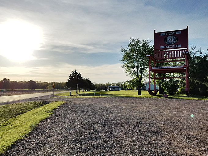 As the sun sets on Route 66, the Red Rocker stands silhouetted against the fading light, a sentinel watching over the historic highway's enduring legacy.