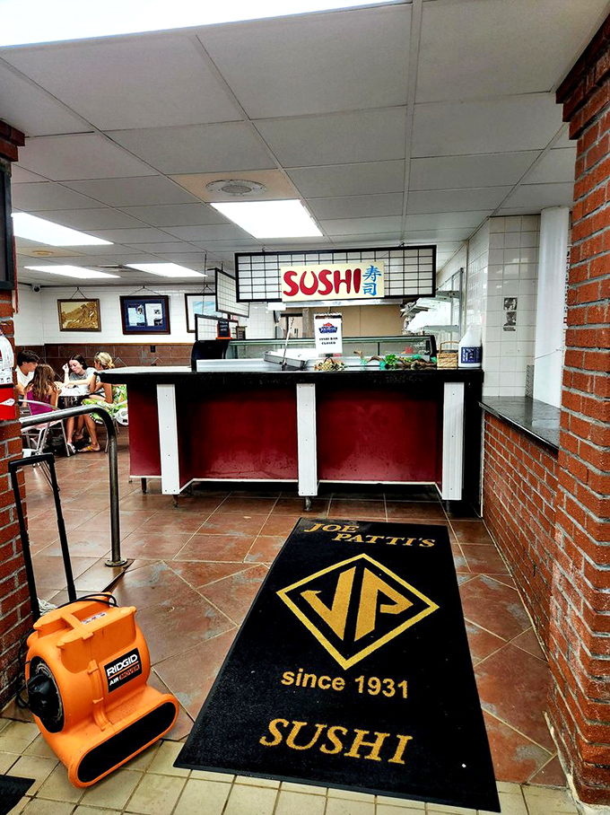 The sushi counter stands ready for action with its bold sign and welcoming mat—a Japanese tradition that's found a perfect home in Florida's seafood paradise.