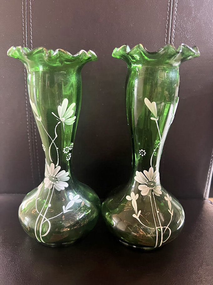 These emerald glass vases with delicate flower details might have graced someone's mantel for decades before landing here, waiting for their second act.