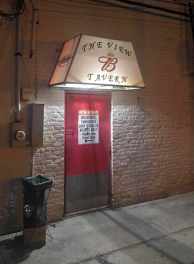 The back entrance illuminated at night looks like the doorway to a secret club. The red door practically whispers, "Trust me, the food is worth finding us."