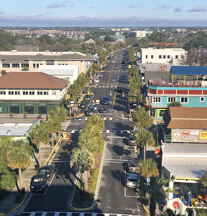 Center Street from above reveals the perfect beach town layout. Palm trees stand at attention along this artery that pumps life into Folly's sun-soaked heart.