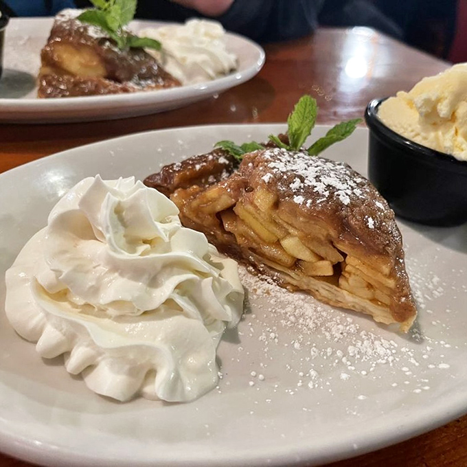 This isn't just apple pie&mdash;it's a warm, cinnamon-scented hug on a plate, complete with a cloud of whipped cream and a scoop of nostalgia.