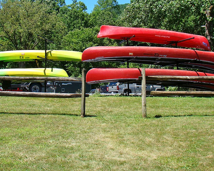 Kayaks rest between adventures, their bright colors popping against the green backdrop like exclamation points in nature's story.