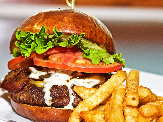 A burger that requires both hands and several napkins. The brioche bun trying to contain all that goodness deserves a medal for effort.