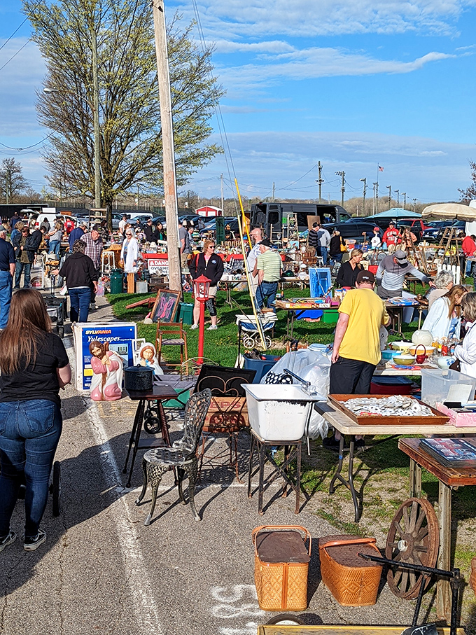 The thrill of the hunt in action! Seasoned shoppers scan tables with the focus of detectives, knowing treasures hide in plain sight.