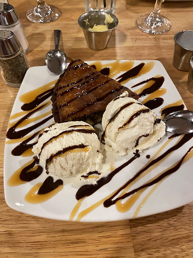 Dessert that doesn't whisper but announces itself with authority. Three scoops of ice cream flanking what appears to be the brownie that dreams are made of.