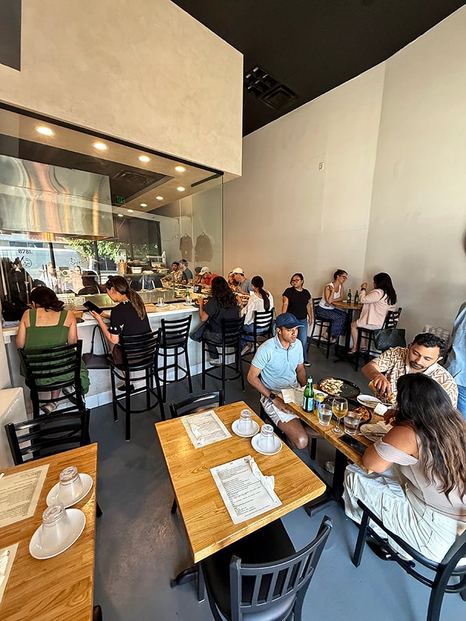 The dining room hums with the universal language of pizza appreciation. Notice how nobody's looking at their phones? That's the power of perfect food.