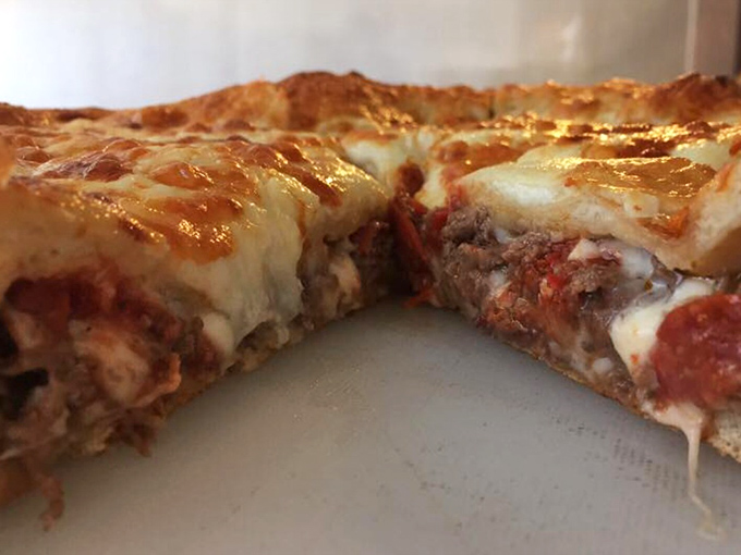 The cross-section of this pizza reveals layers of meaty treasure that would make archaeologists weep with joy.